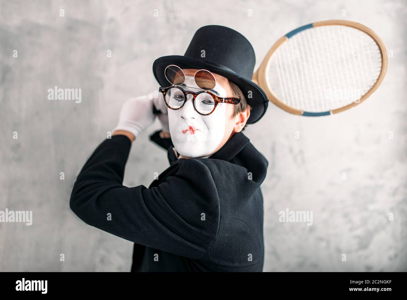 Pantomime actor performing with badminton racket. Comedy mime artist in ...