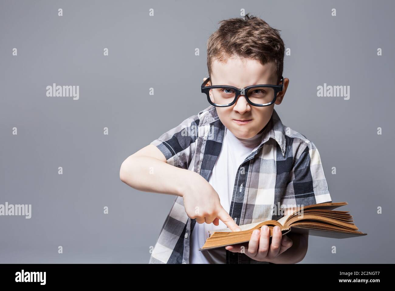 Strict boy in glasses with book in hands, studio photo shoot. School ...