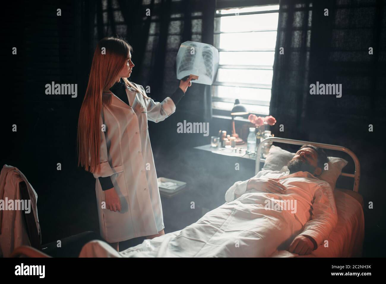 Female doctor looking at x-ray picture of sick man in hospital ...