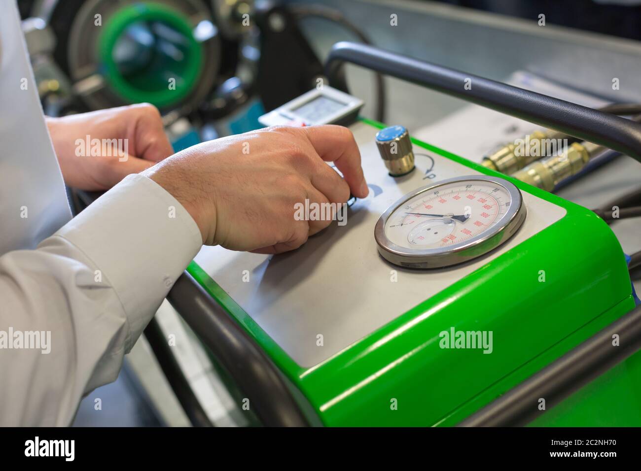 Mechanic working with compressor at workroom Stock Photo - Alamy