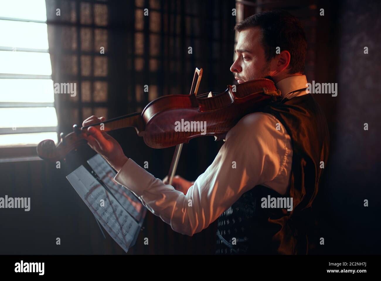 Portrait of male fiddler playing classical music on violin. Violinist ...