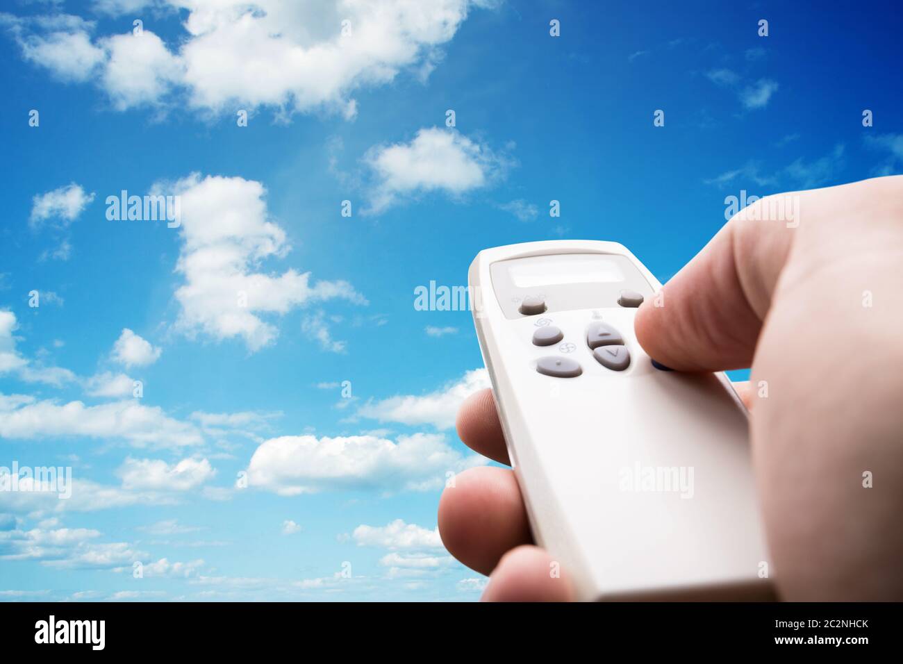 Hand holding remote control against blue sky Stock Photo - Alamy