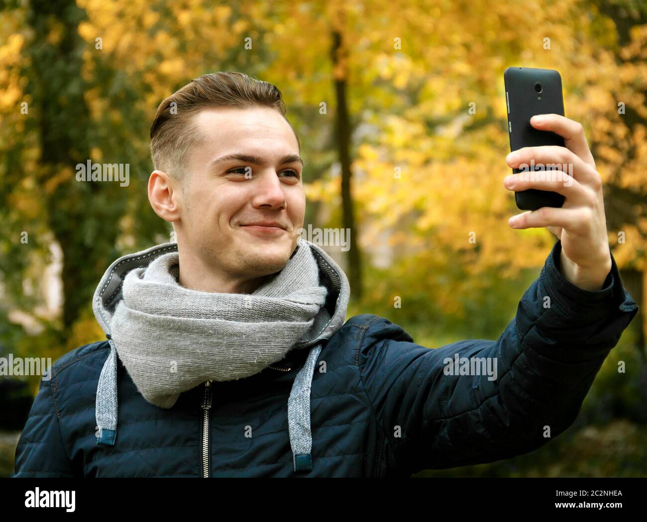Cute young man with smartphone Stock Photo - Alamy