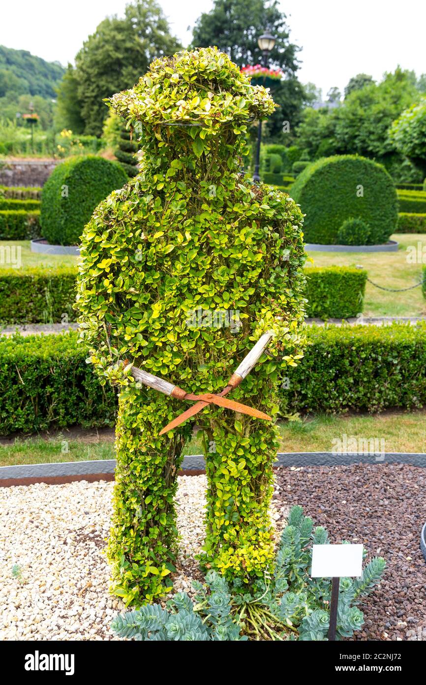 Figure in shape of lawn mower from the bushes, summer park in Europe ...