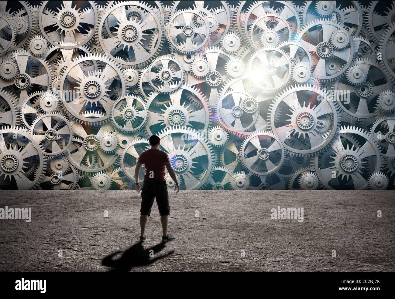 Silhouette of man standing against background of gears and cogwheels ...