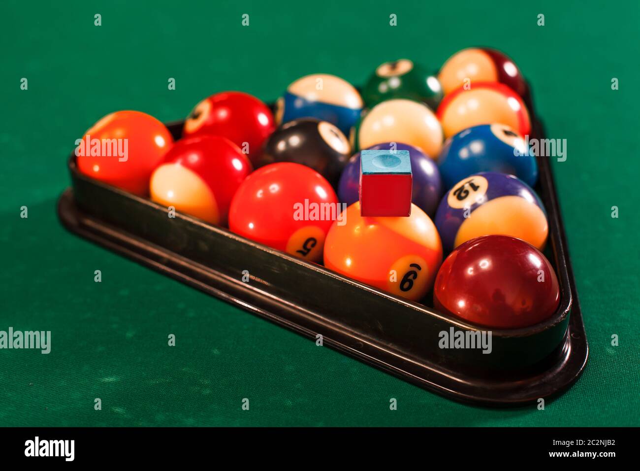 Balls in a pool triangle on the table. Green cloth Stock Photo - Alamy