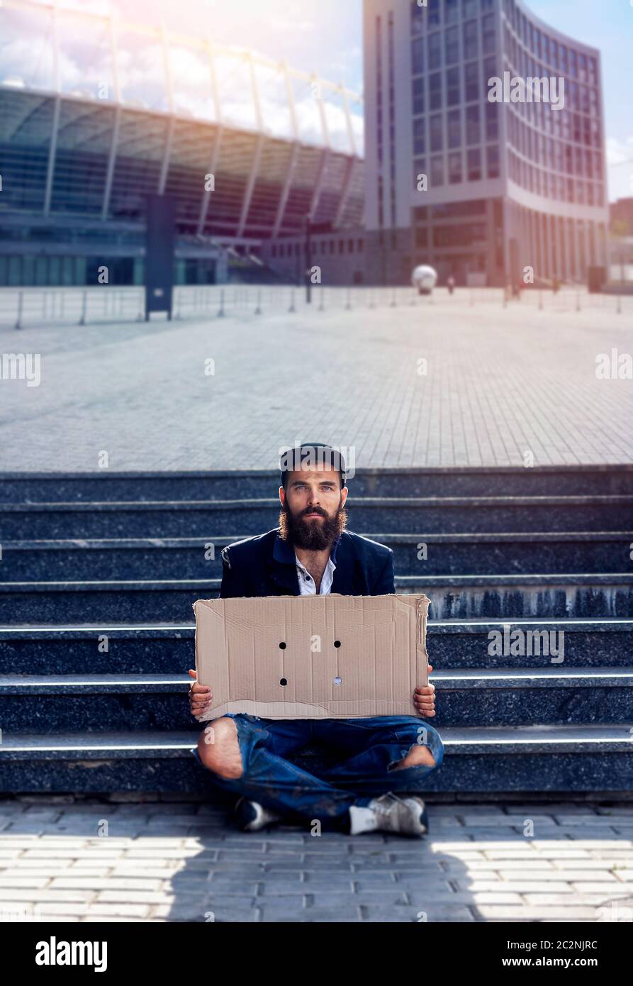Homeless sitting with pieces of cardboard at the steps Stock Photo - Alamy