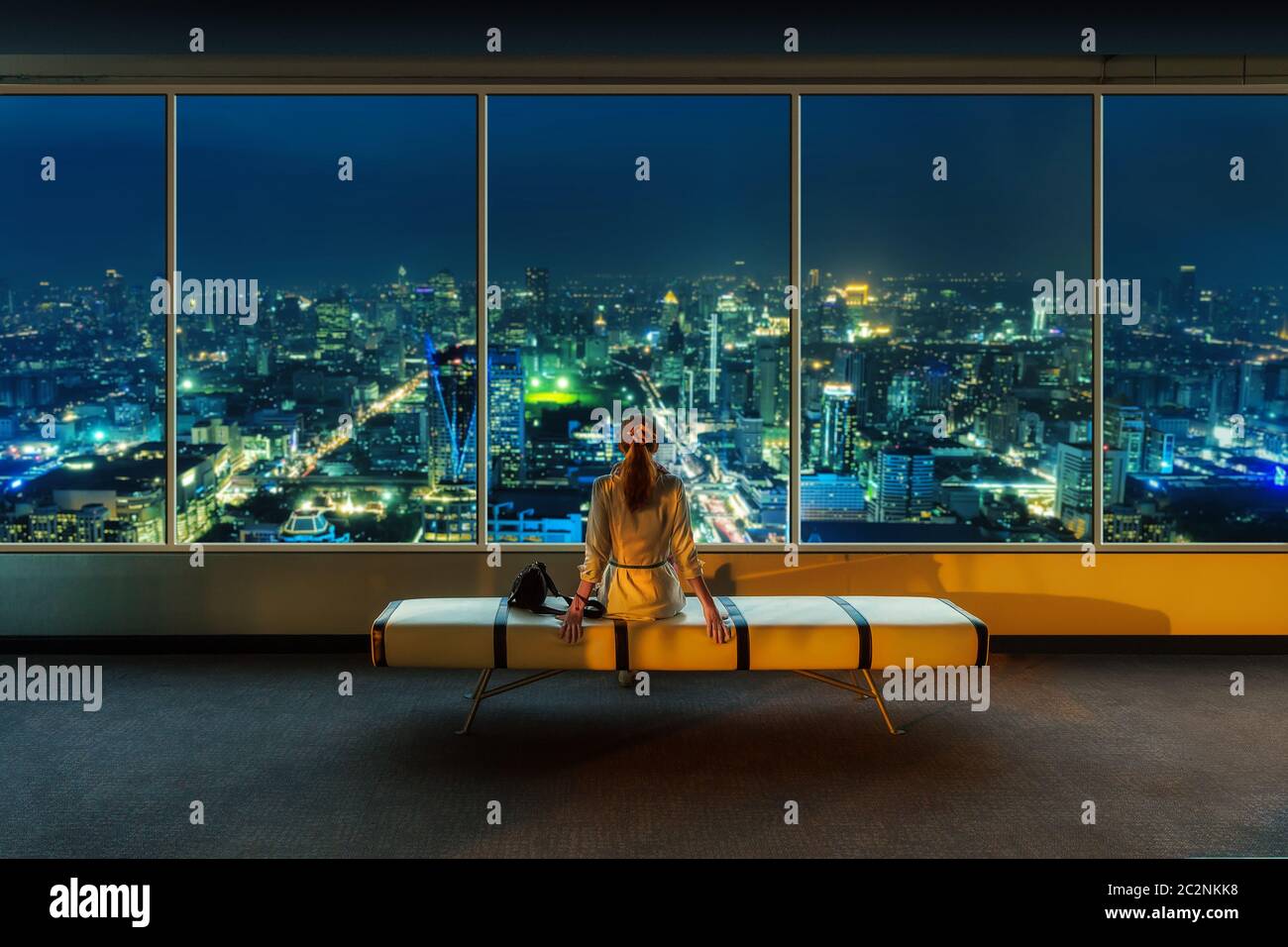 Woman look out the window at night cityscape Stock Photo - Alamy
