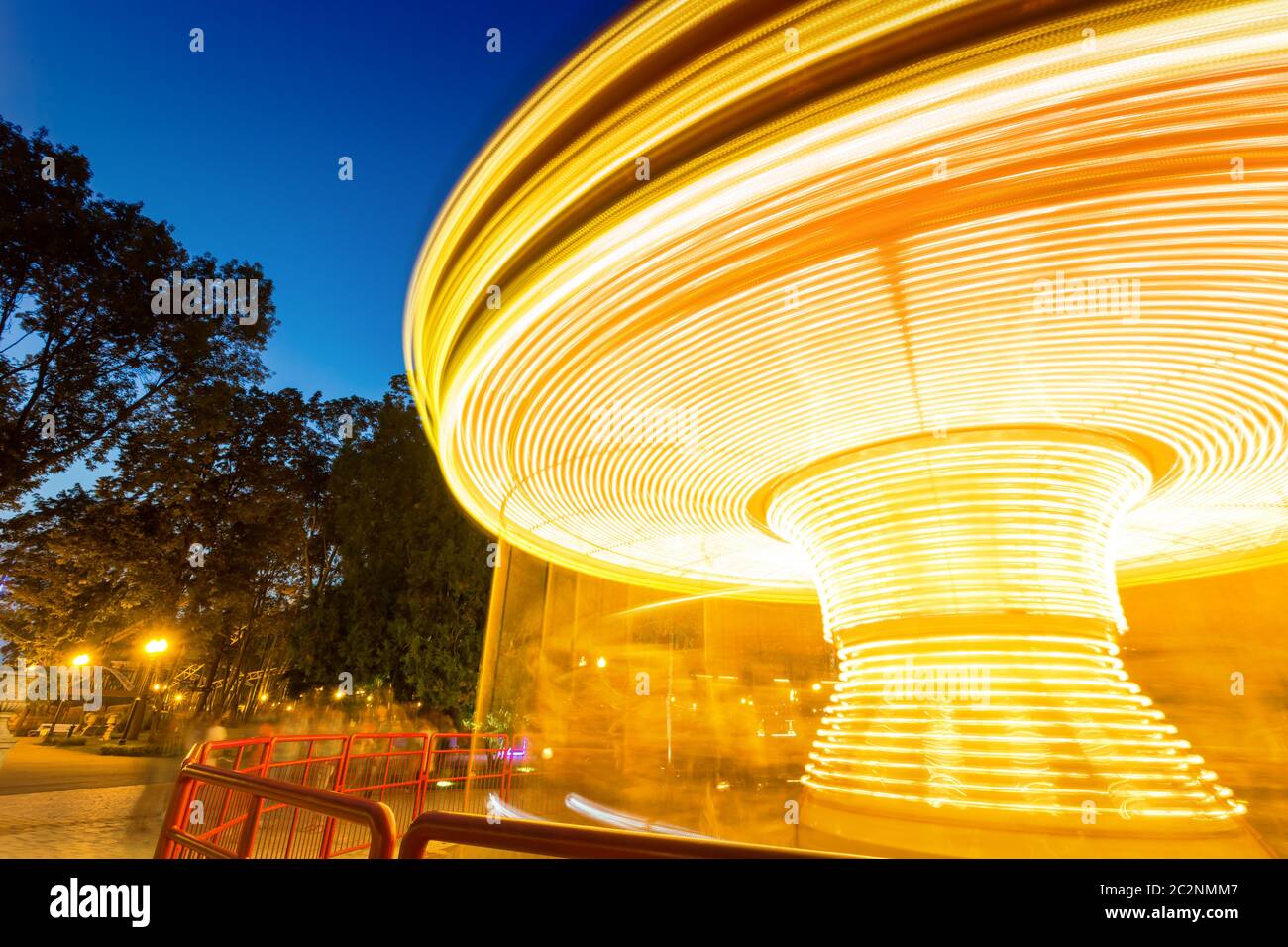 Fast merry-go-round lighting in the night Stock Photo - Alamy