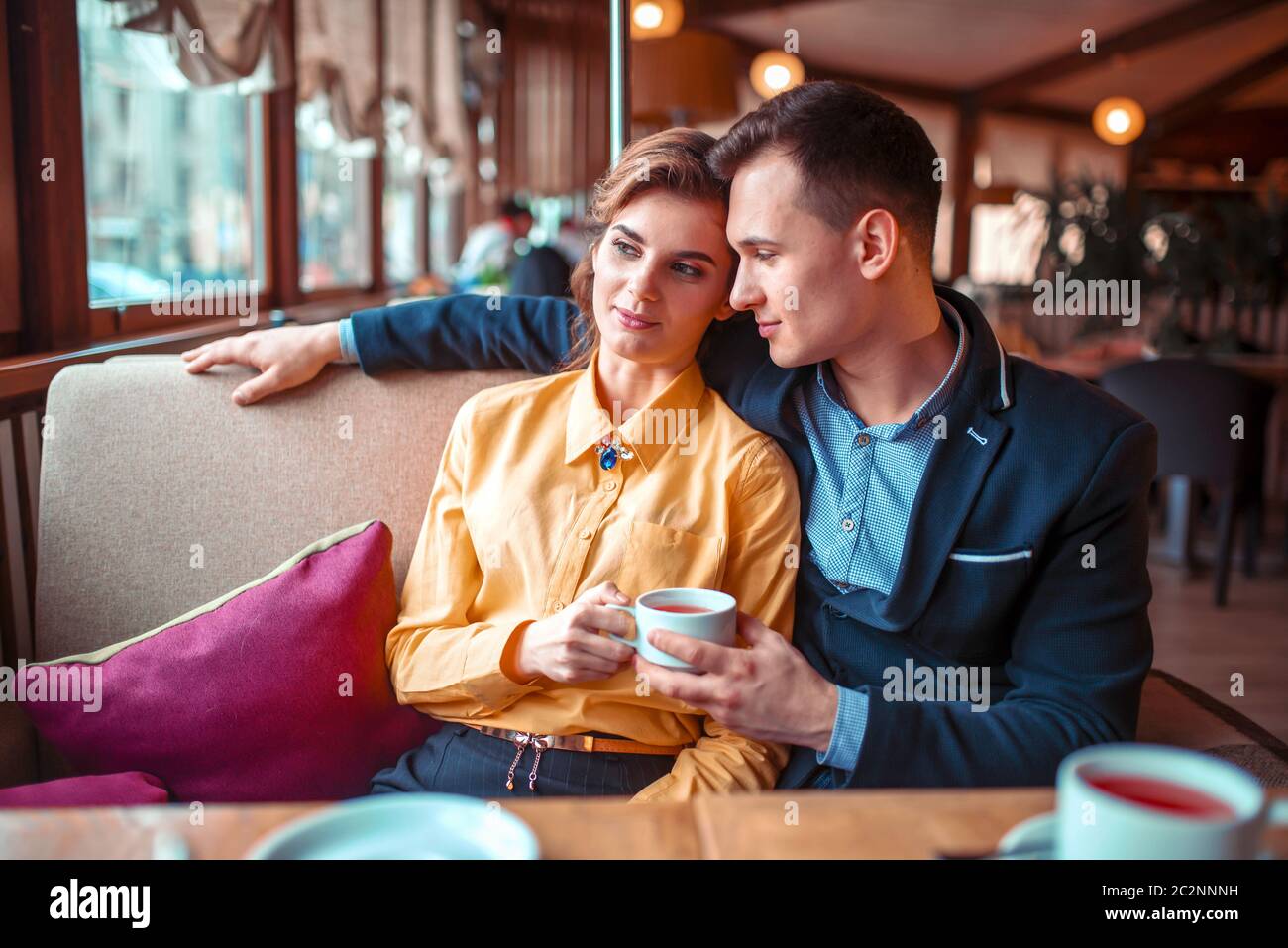 Love couple hugs and looking at the window in restaurant. Man and woman ...