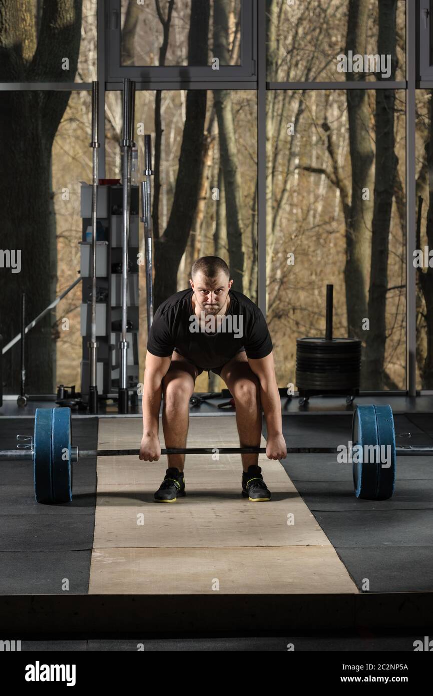 Deadlift attempt. Young man trying to lift heavy barbell Stock Photo ...