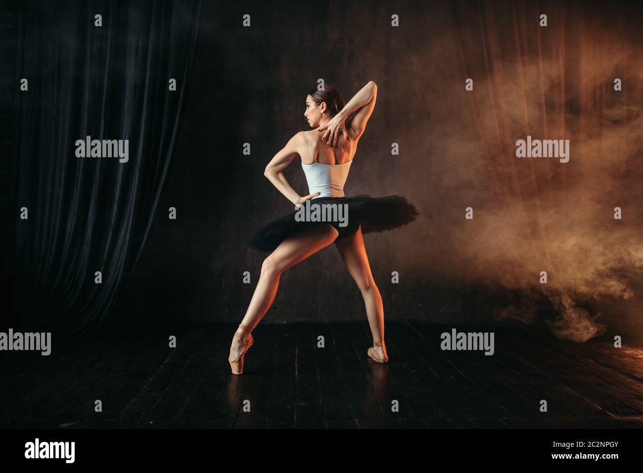 Attractive ballerina in action, dance training on the stage. Classical ...