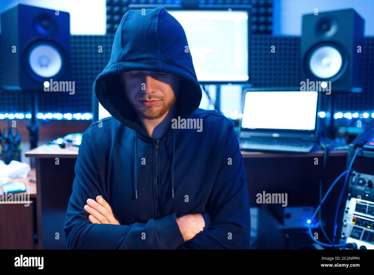 Hacker in hood at his workplace with laptop and PC, password or account ...