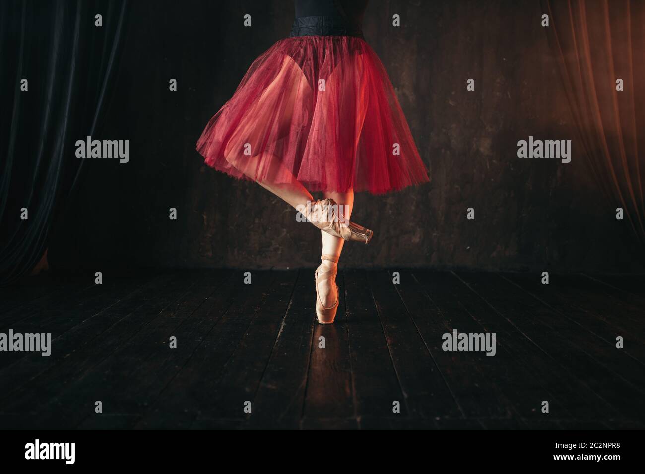 Female ballet dancer legs in pointes. Ballerina in red dress and black ...