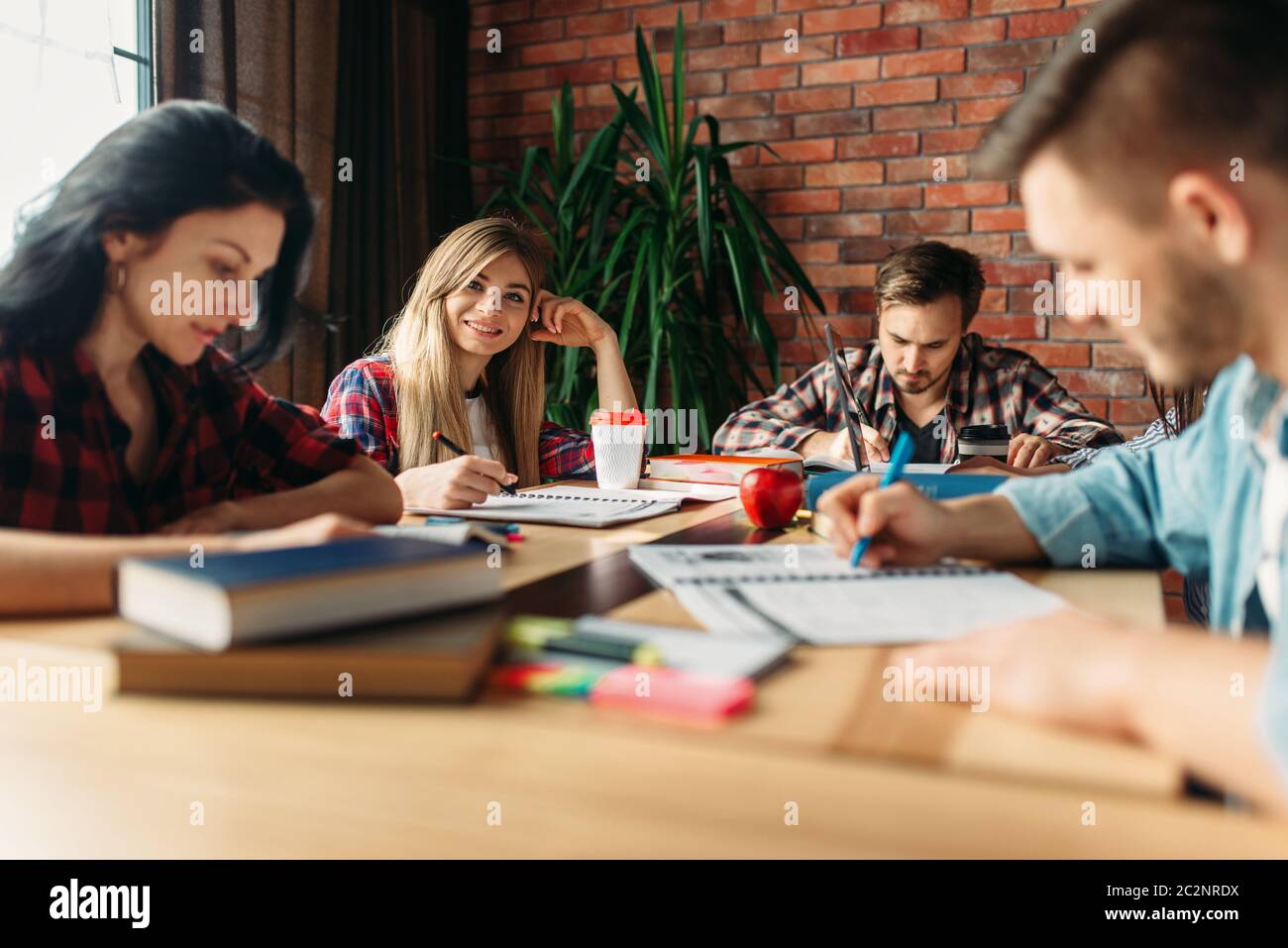 Group of students studying at the table together Stock Photo - Alamy