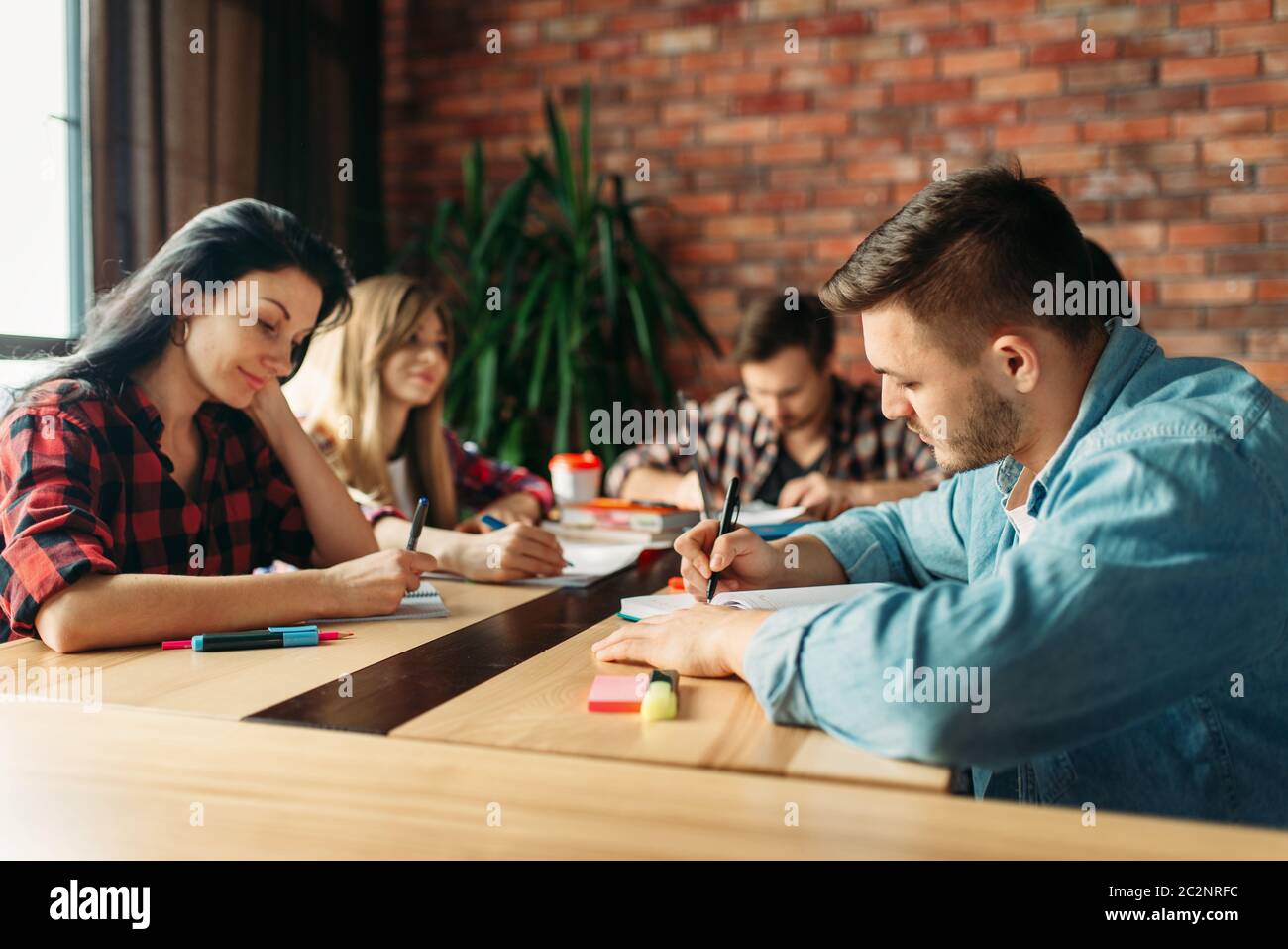 Group of highschool students prepares teamwork project. People studying ...