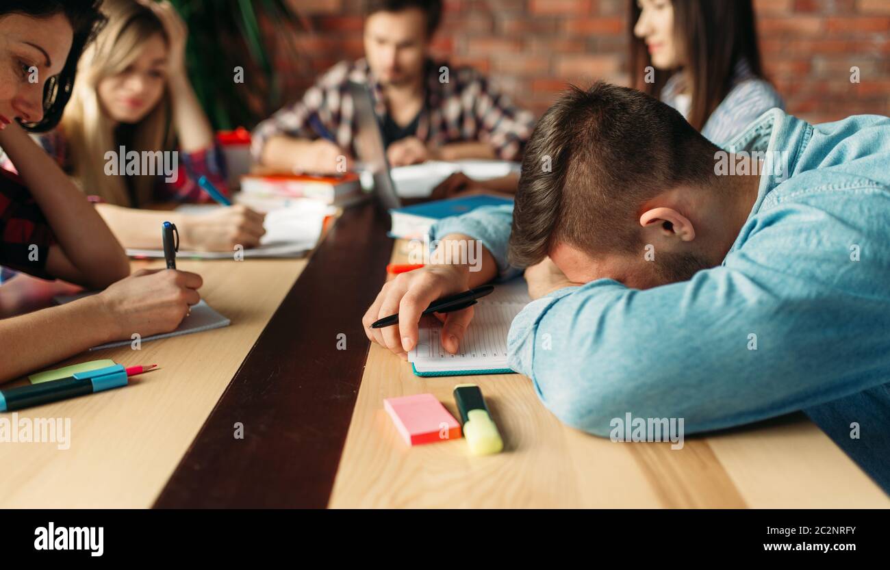 Group of tired highschool students prepares for exams. People studying ...