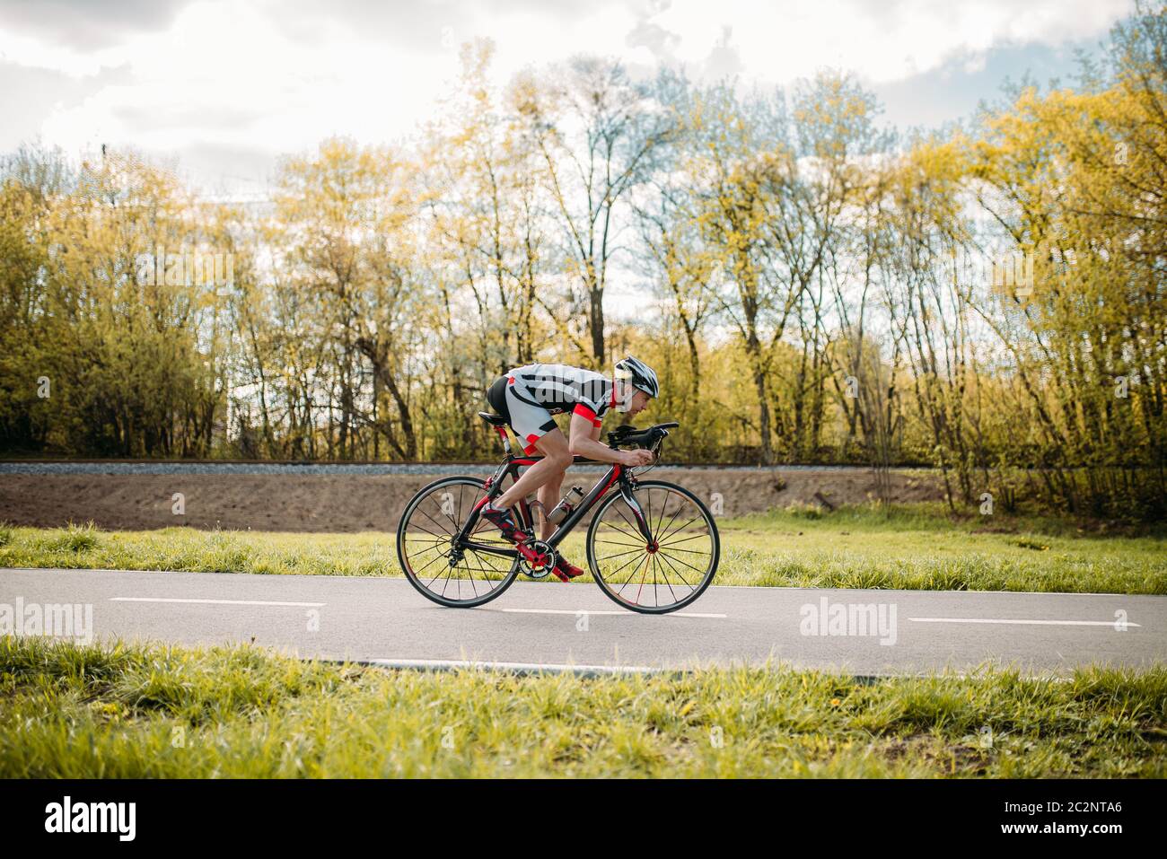 Cyclist in helmet and sportswear rides on bicycle, speed effect, side ...