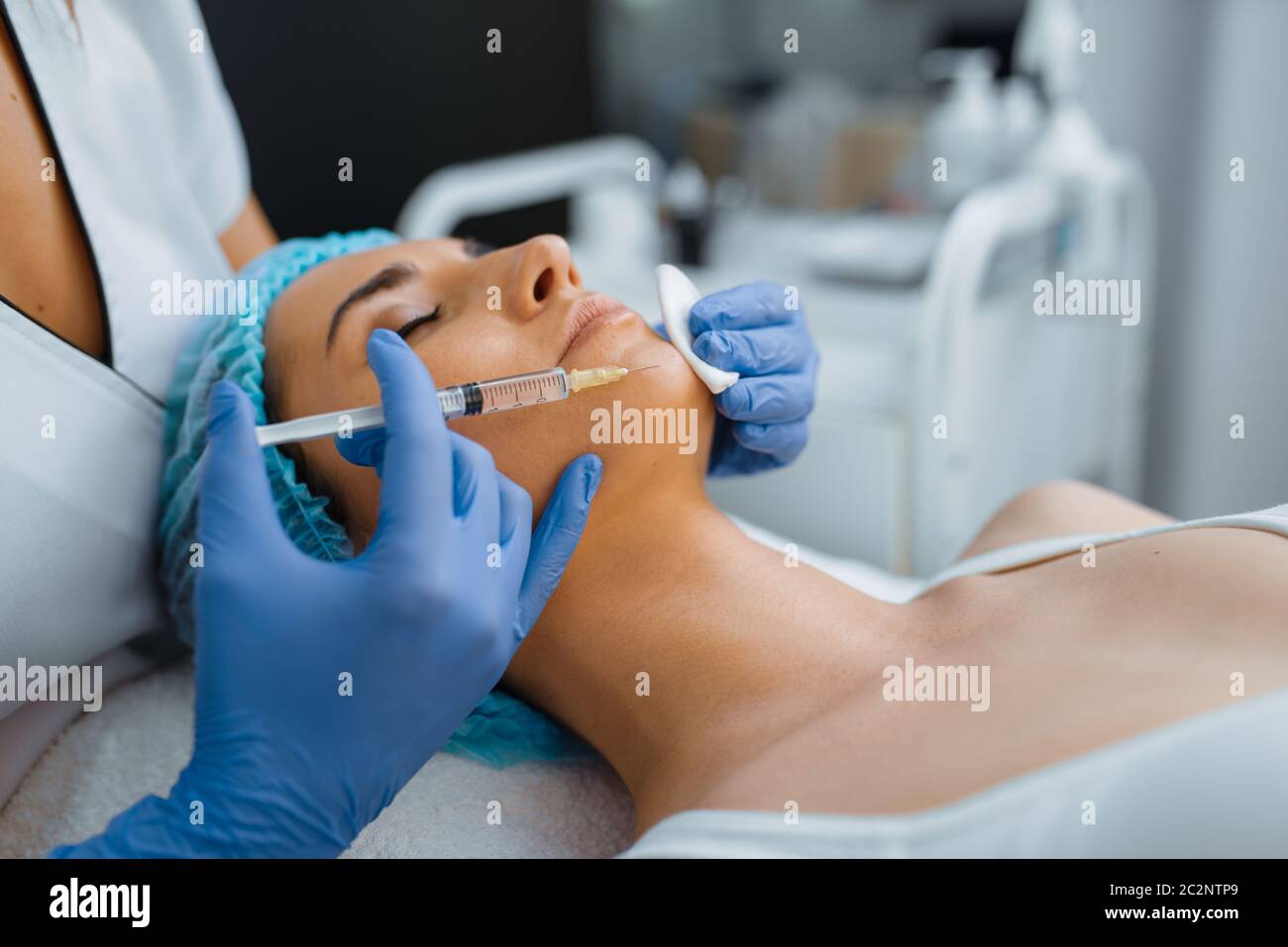 Cosmetician in gloves gives chin botox injection to female patient on ...