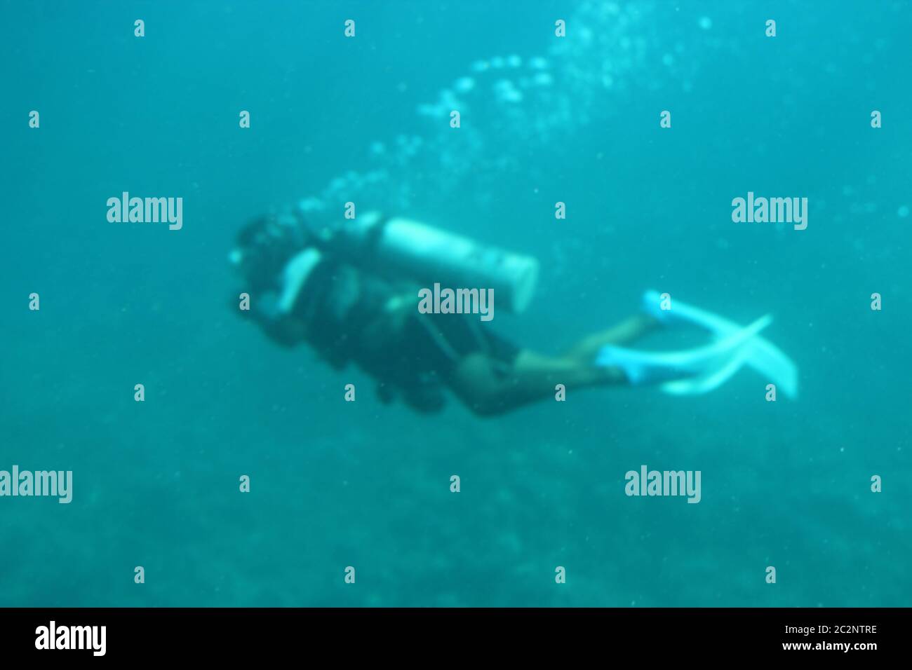 Diver in mask flippers and with oxygen balloons diving in sea water ...