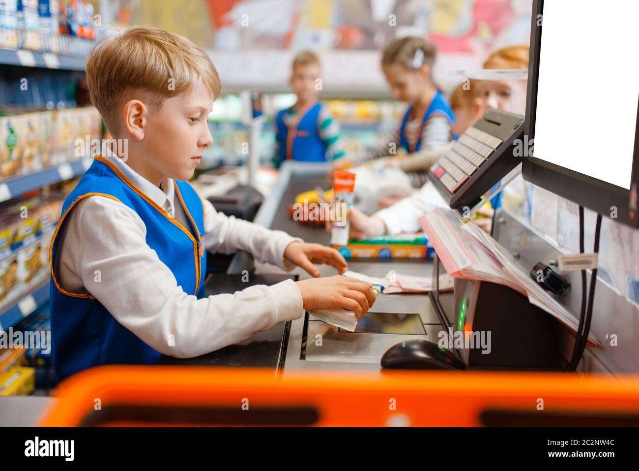 Little boy in uniform at the register playing salesman, playroom. Kids ...