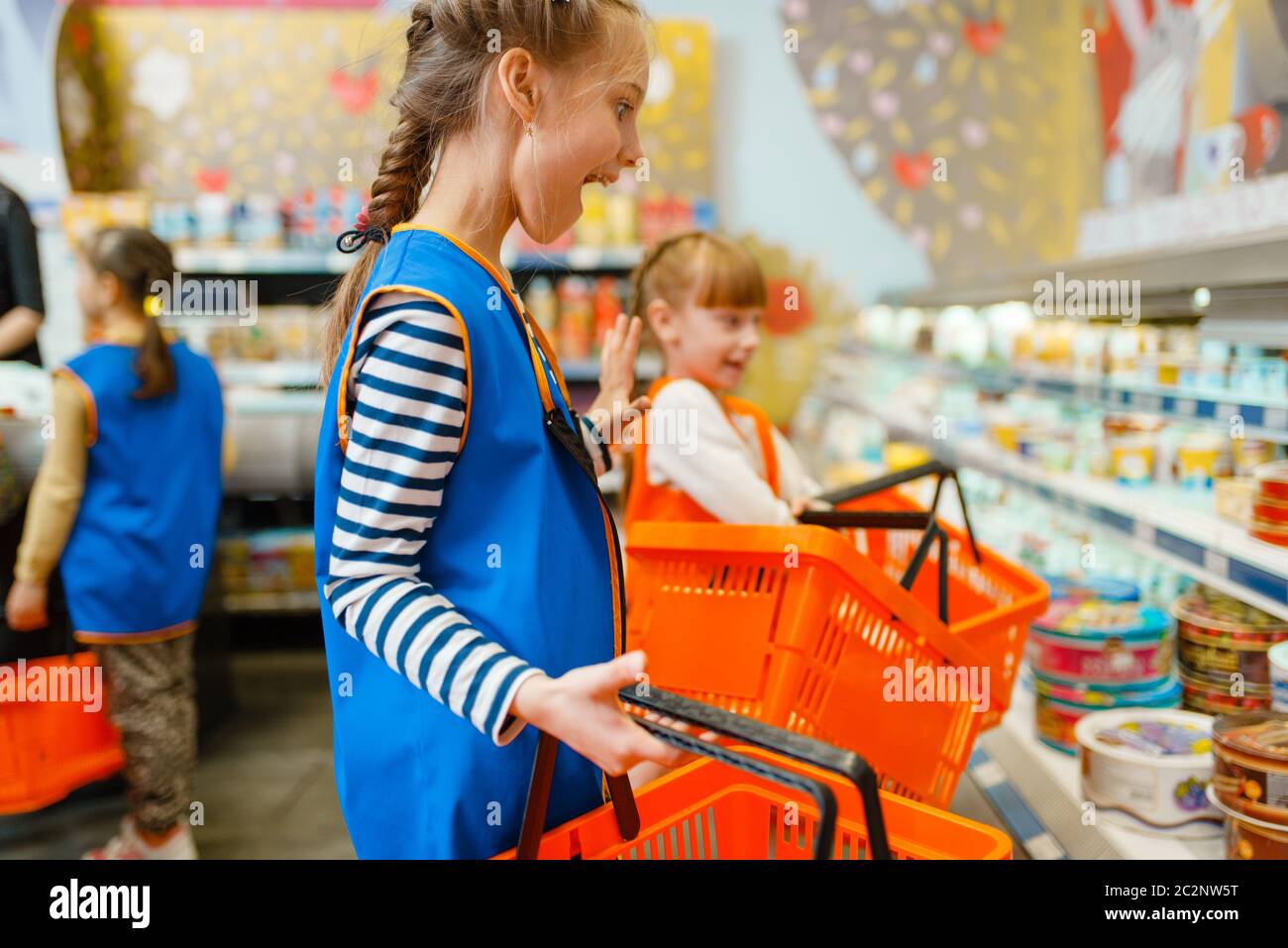 Little girls in uniform with baskets at the showcase, playroom. Kids ...