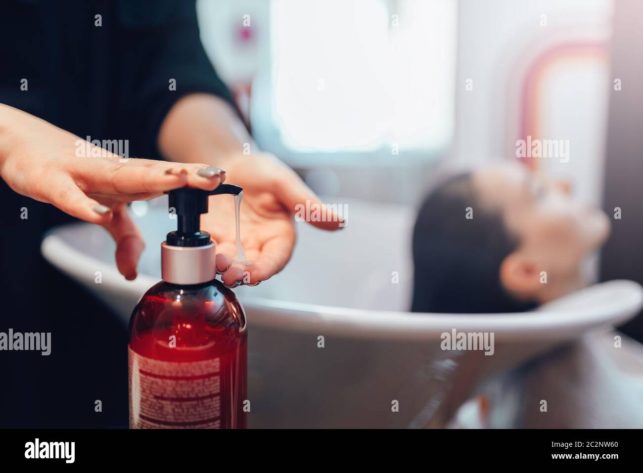 Female hairdresser washes customer hair with shampoo, hairdressing ...