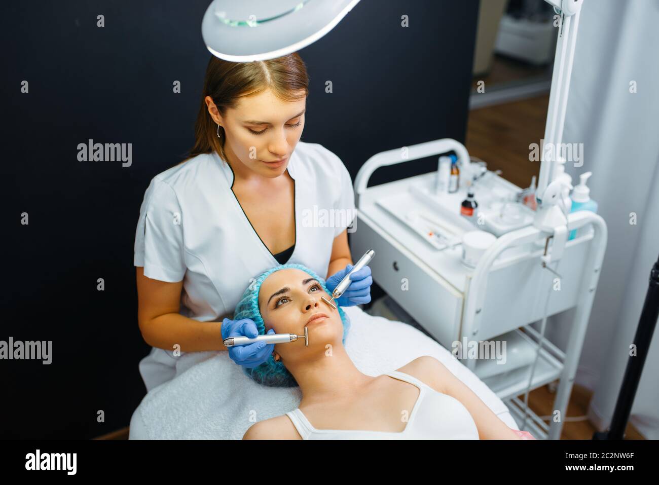 Cosmetician smoothes face of female patient after botox injections ...