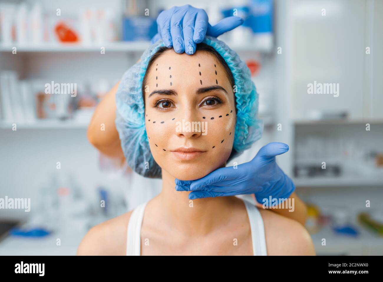 Cosmetician and female patient with markers on her face. Rejuvenation ...