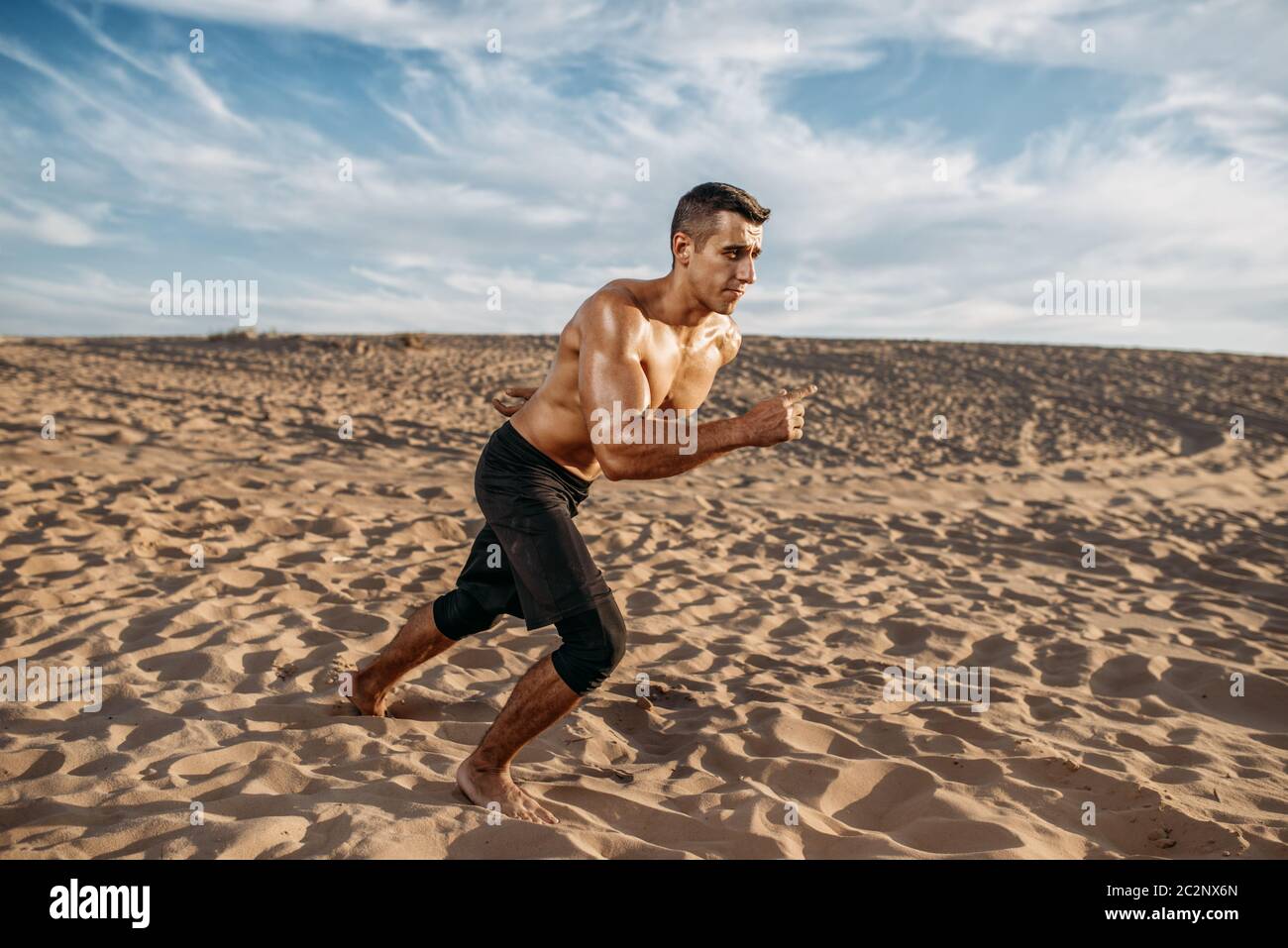 Male athlete on running workout in desert at sunny day. Strong ...