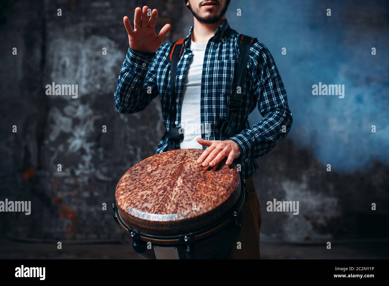 Male drummer playing on wooden drum, musician in motion. Bongo, musical ...