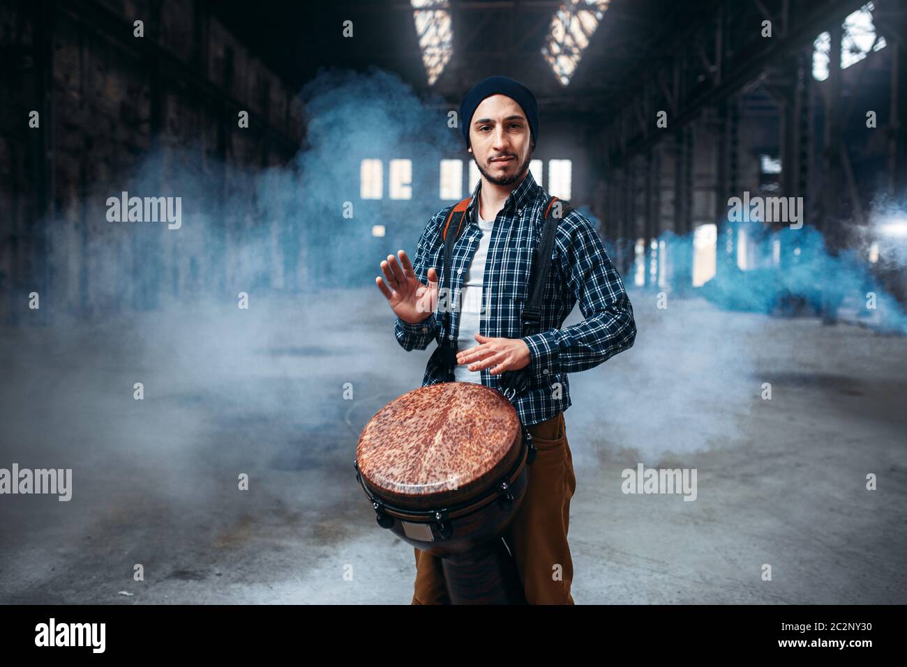 Male drummer playing on wooden drum, musician in motion. Bongo, musical ...