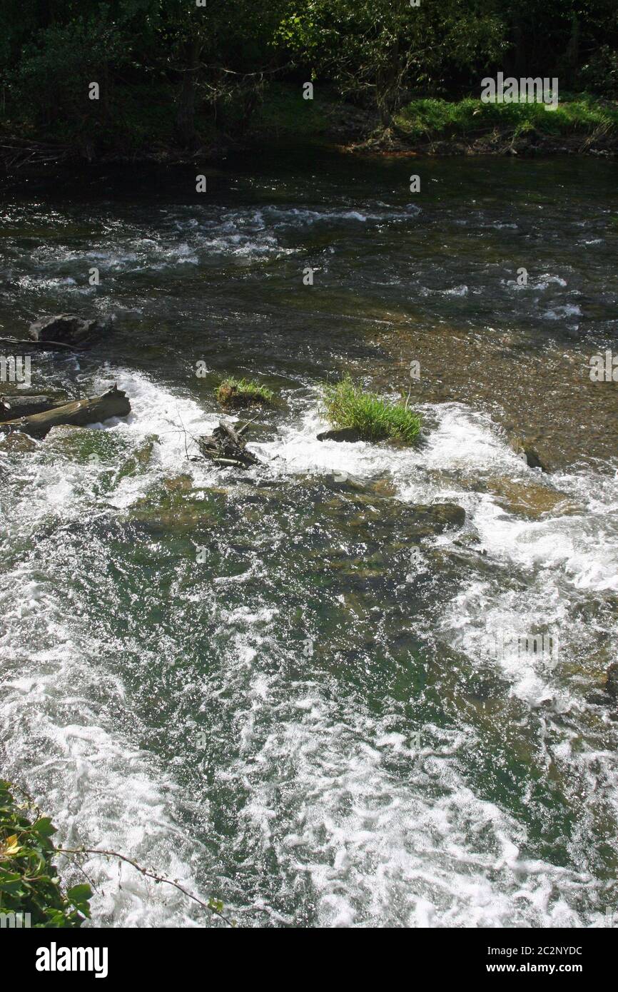 Weir on river with the water blurred as it falls over the weir ...