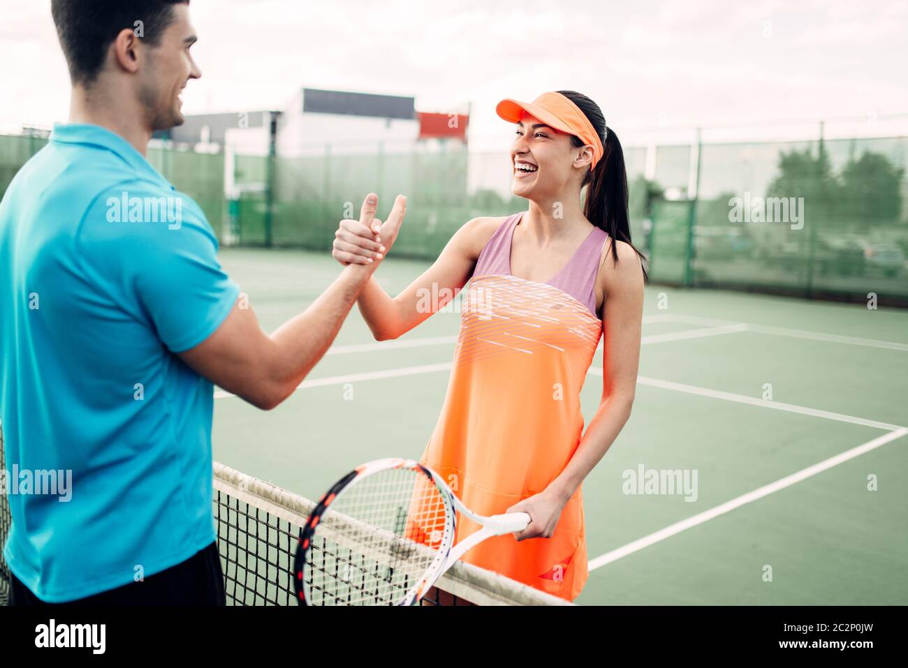 Man and woman partners on outdoor tennis court. Summer season active ...