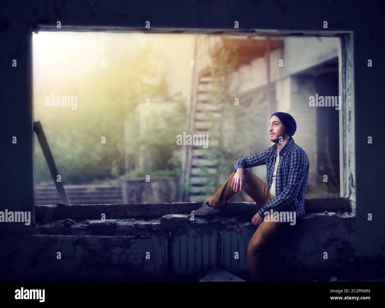 Stalker, male traveler sitting on the window, ruins of the abandoned ...