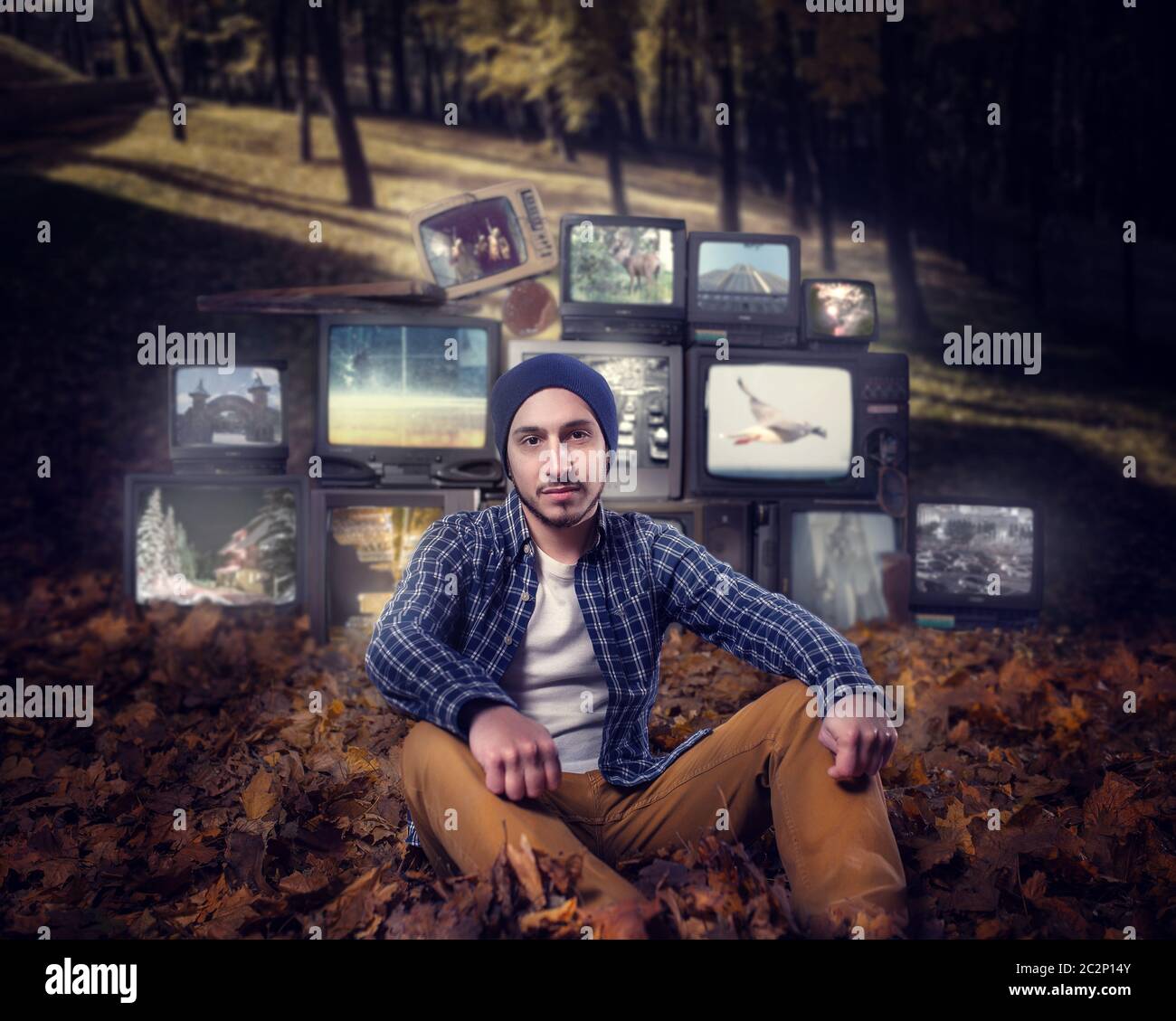 Stalker, male traveler sitting on the ground, the mountain of old TVs ...
