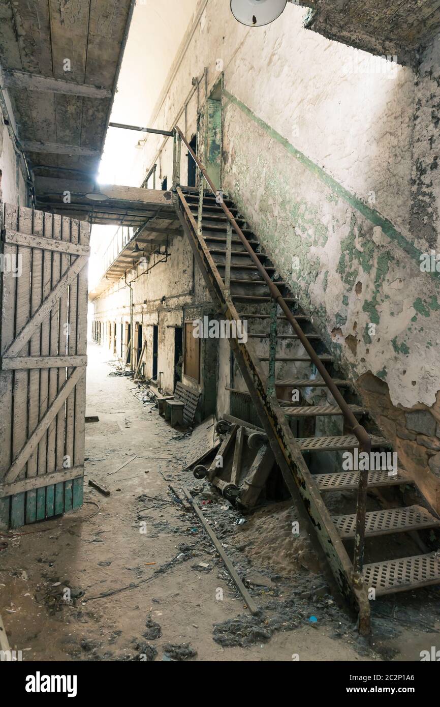 Old prison corridor with grunge wooden staircase and doors Stock Photo ...