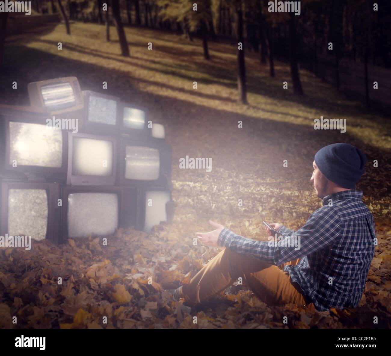 Stalker, male traveler looks at the mountain of old TVs, remains of ...