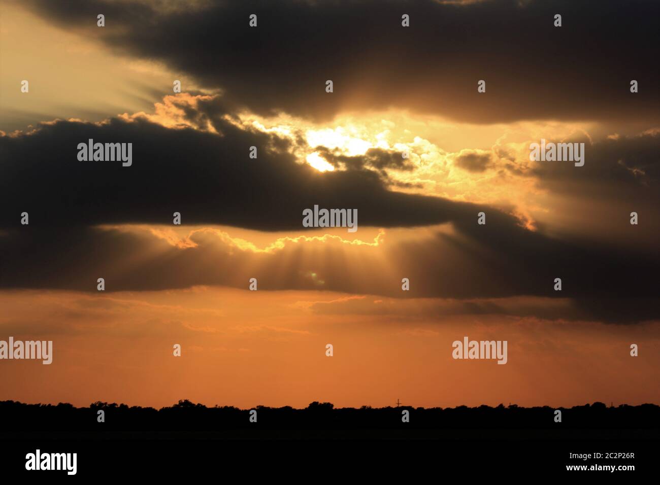 Colorful Sunset with clouds and Sun Rays coming down from above Stock ...