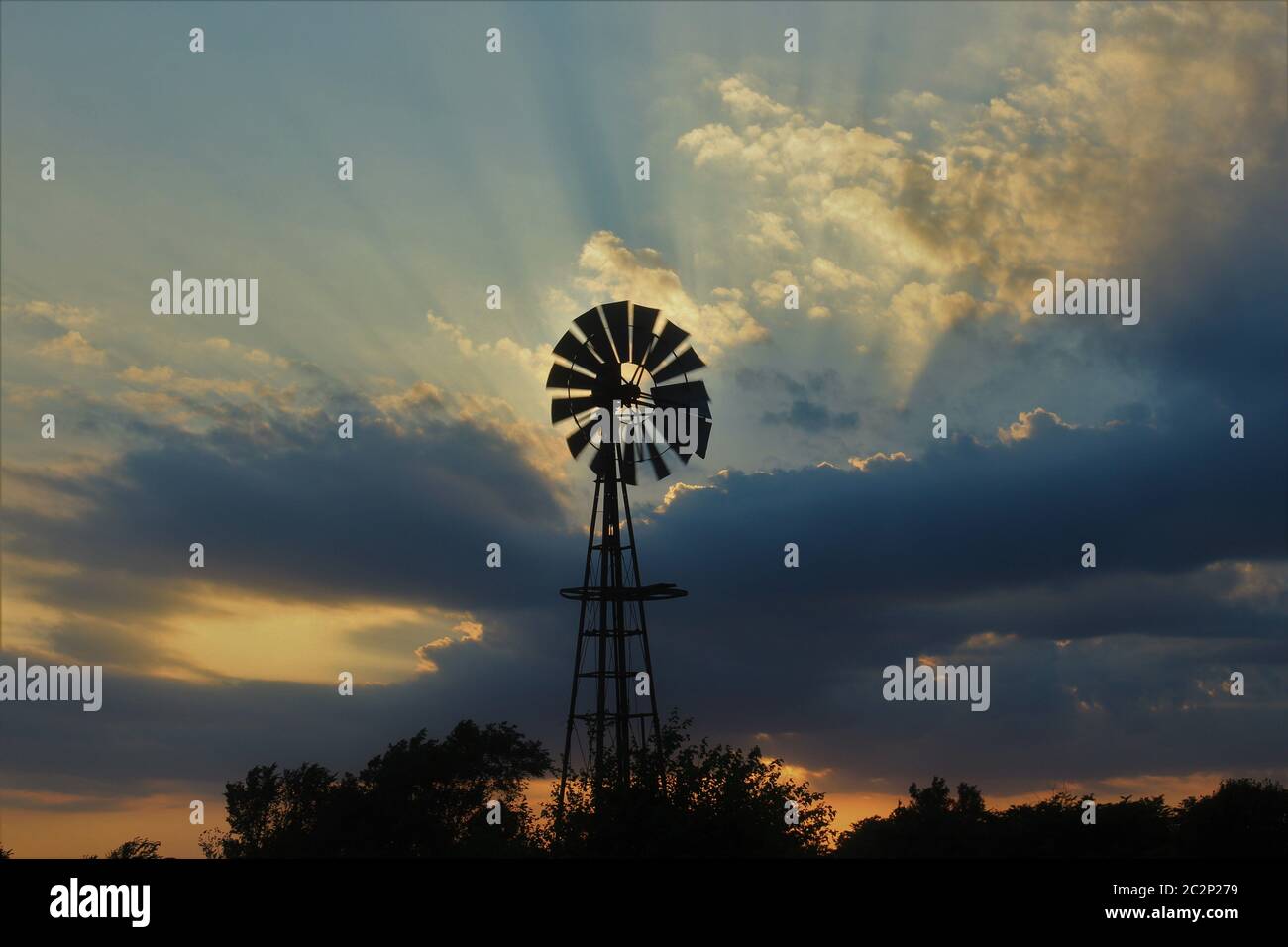 Kansas Country Windmill Silhouette Sunset with clouds and Sun rays ...