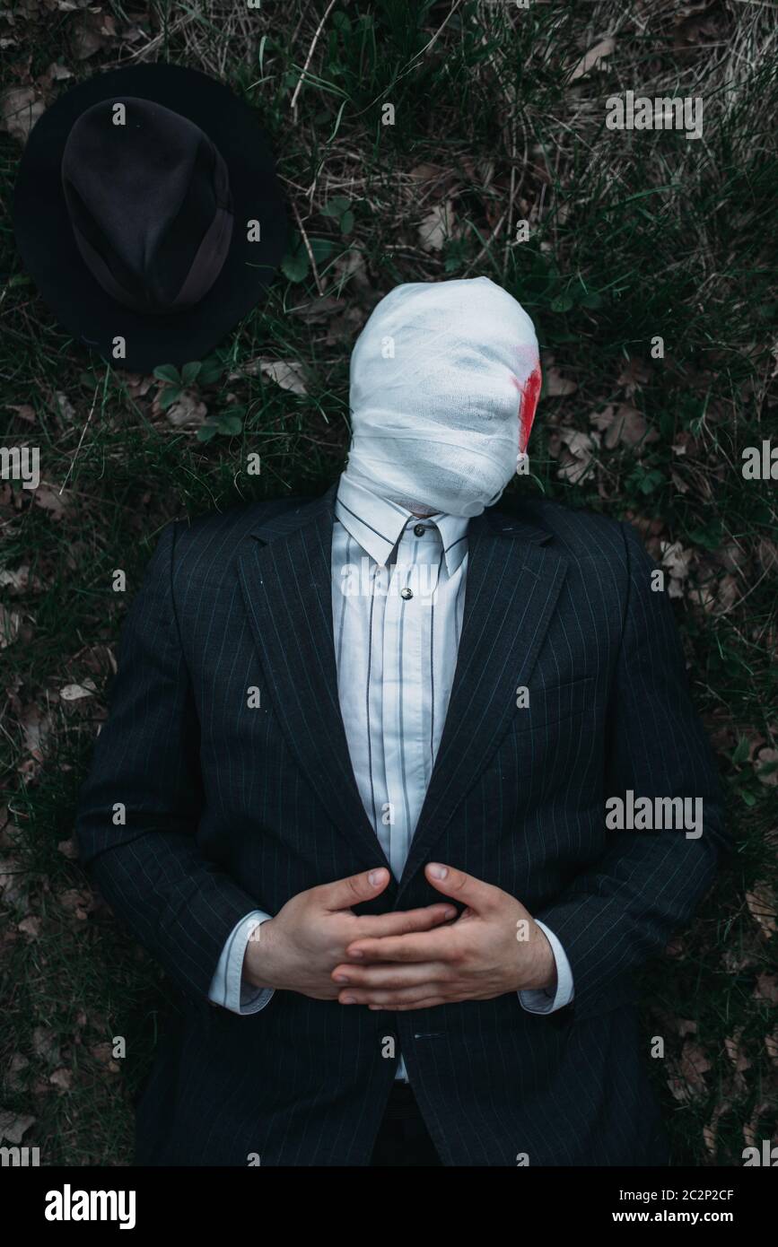 Serial maniac with face wrapped in bloodied bandages lies on the ground ...