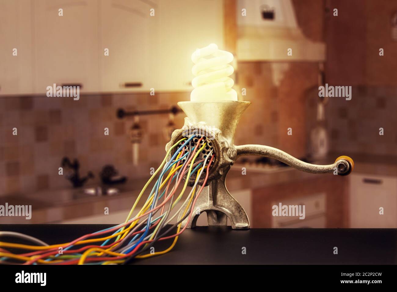 Retro mincing machine is grinding up a lamp to cables Stock Photo - Alamy