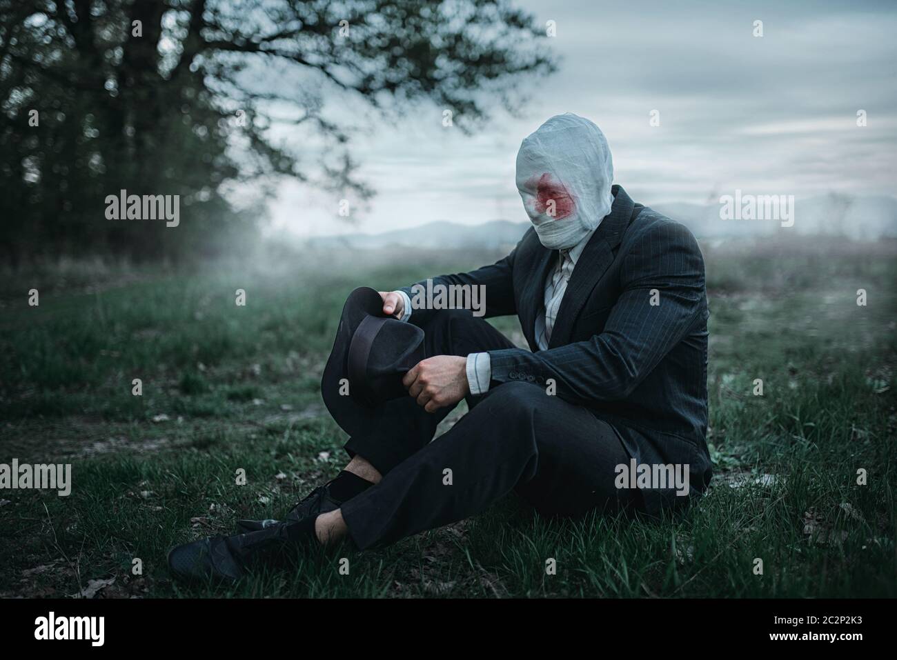 Serial maniac with face wrapped in bloodied bandages sitting on the ...