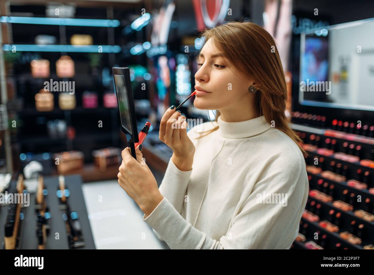 Female customer testing lip liner in the makeup shop. Cosmetics ...