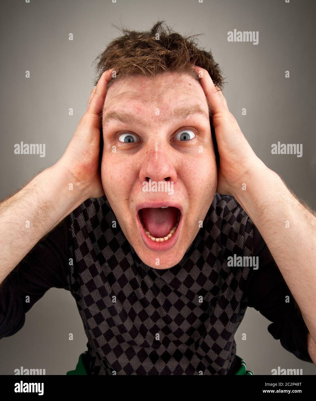 Portrait of screaming surprised man holding head Stock Photo - Alamy