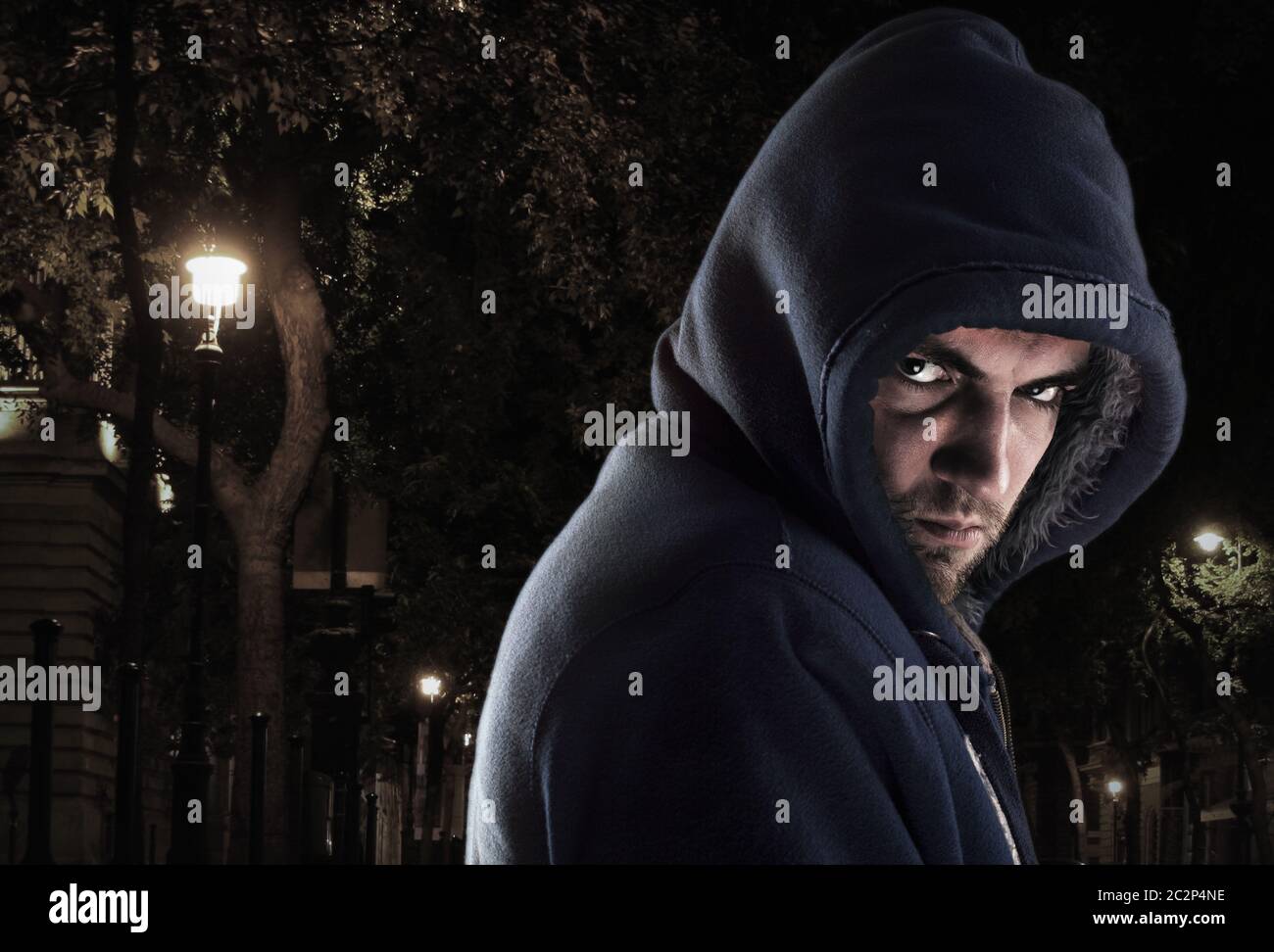 Serious bandit in ghetto at night looking to you Stock Photo - Alamy