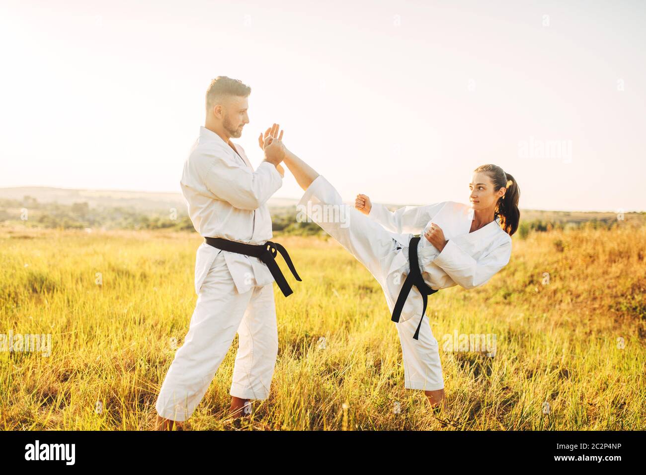 Female karate doing stretching exercise on training with male ...