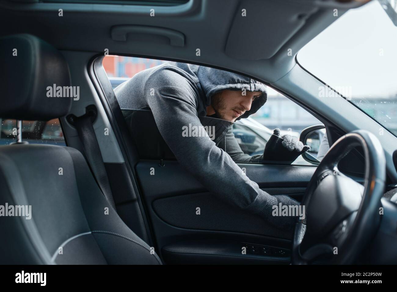 Car robber opening door, risk job, stealing. Hooded male bandit gets ...