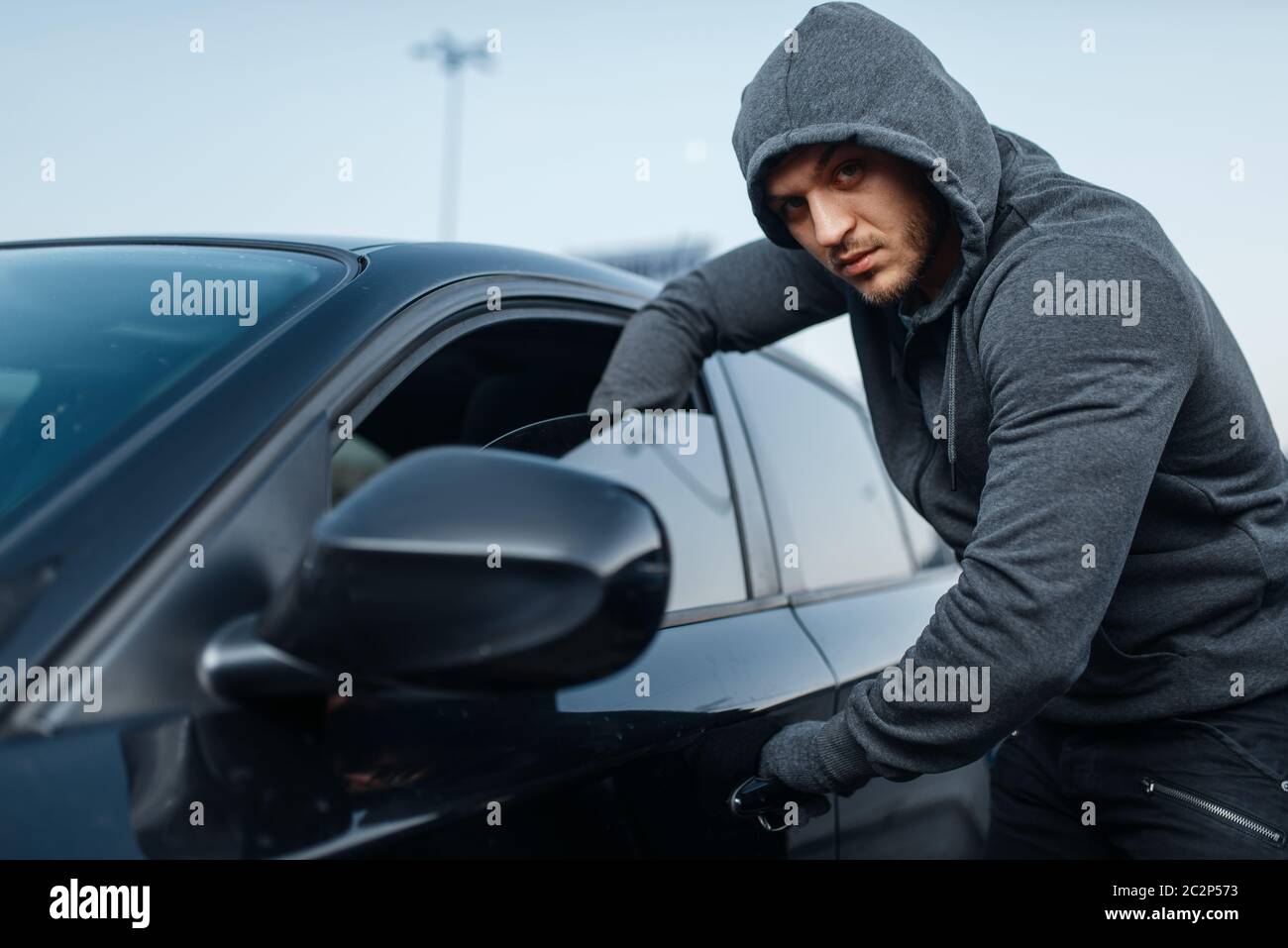 Car thief breaking door, criminal job, burglar, stealing. Hooded male ...
