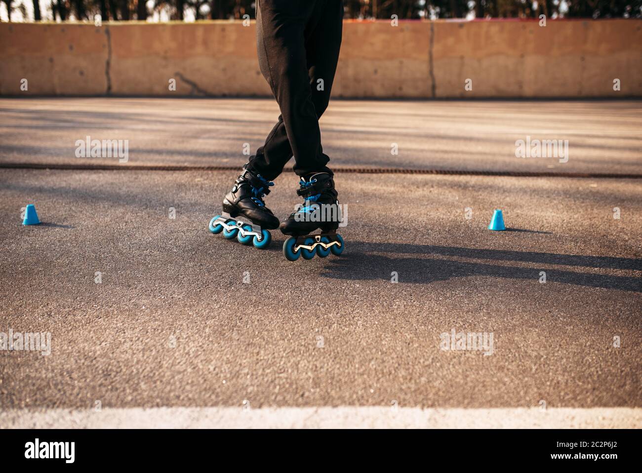 Roller skater legs in skates, balance exercise on sidewalk in city park ...